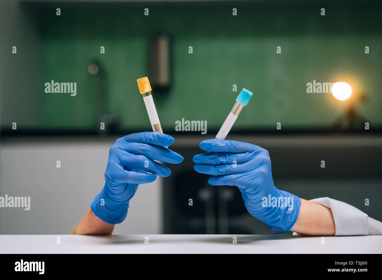 A rubber-gloved hands holds two test tube with the drug Stock Photo - Alamy