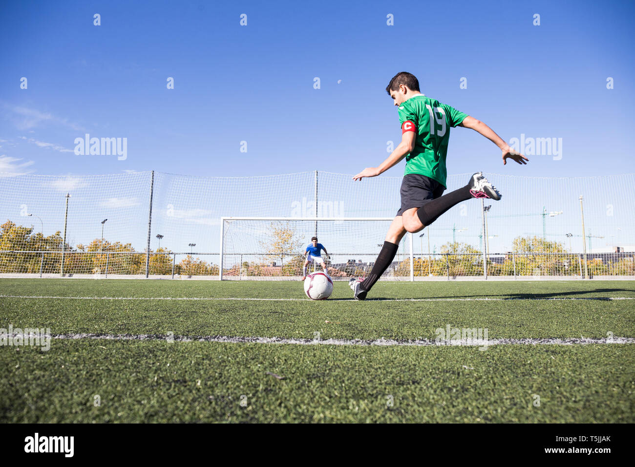 Football player shooting the ball on football field Stock Photo - Alamy