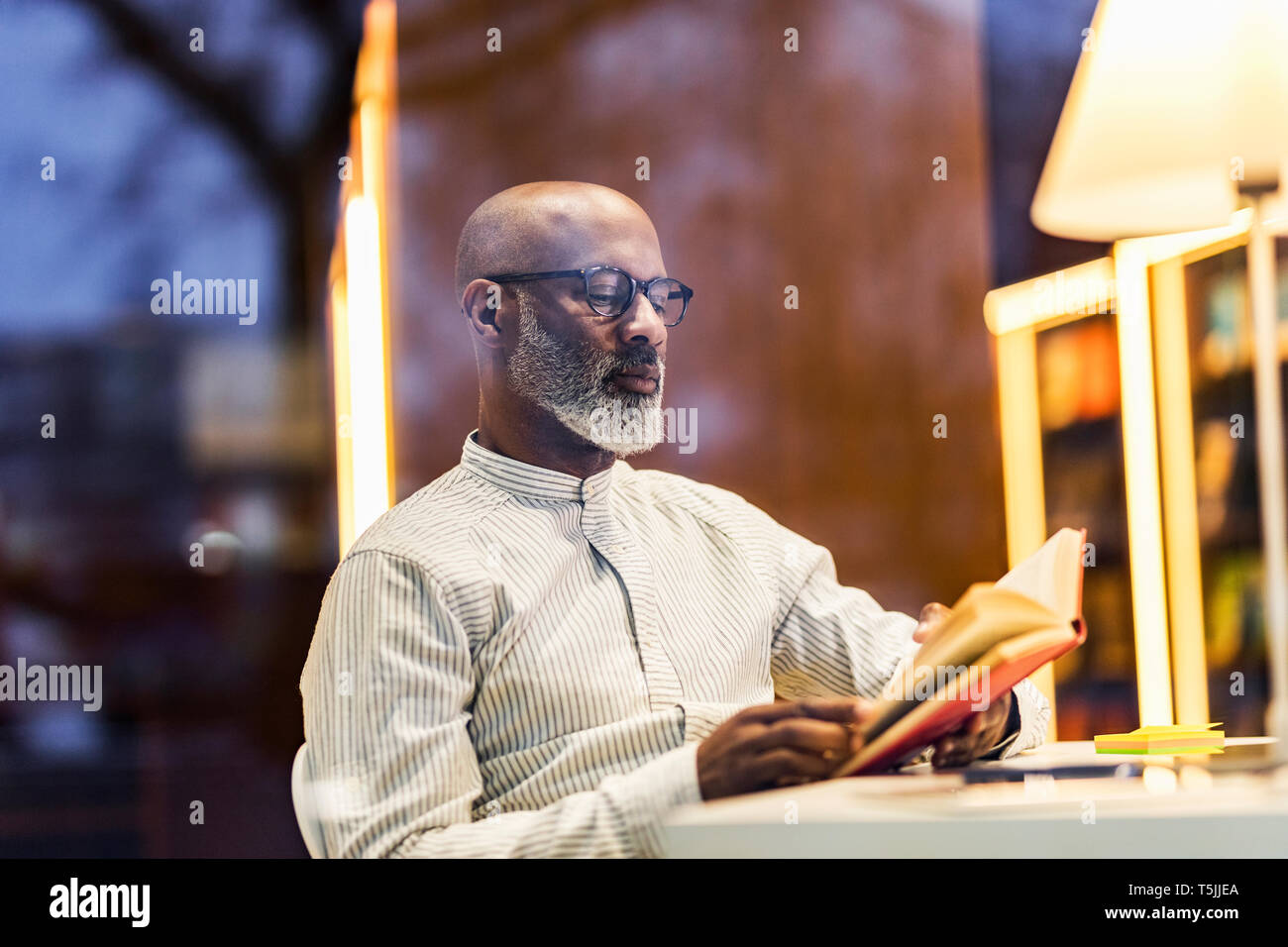 Man in library reading book hi-res stock photography and images - Alamy
