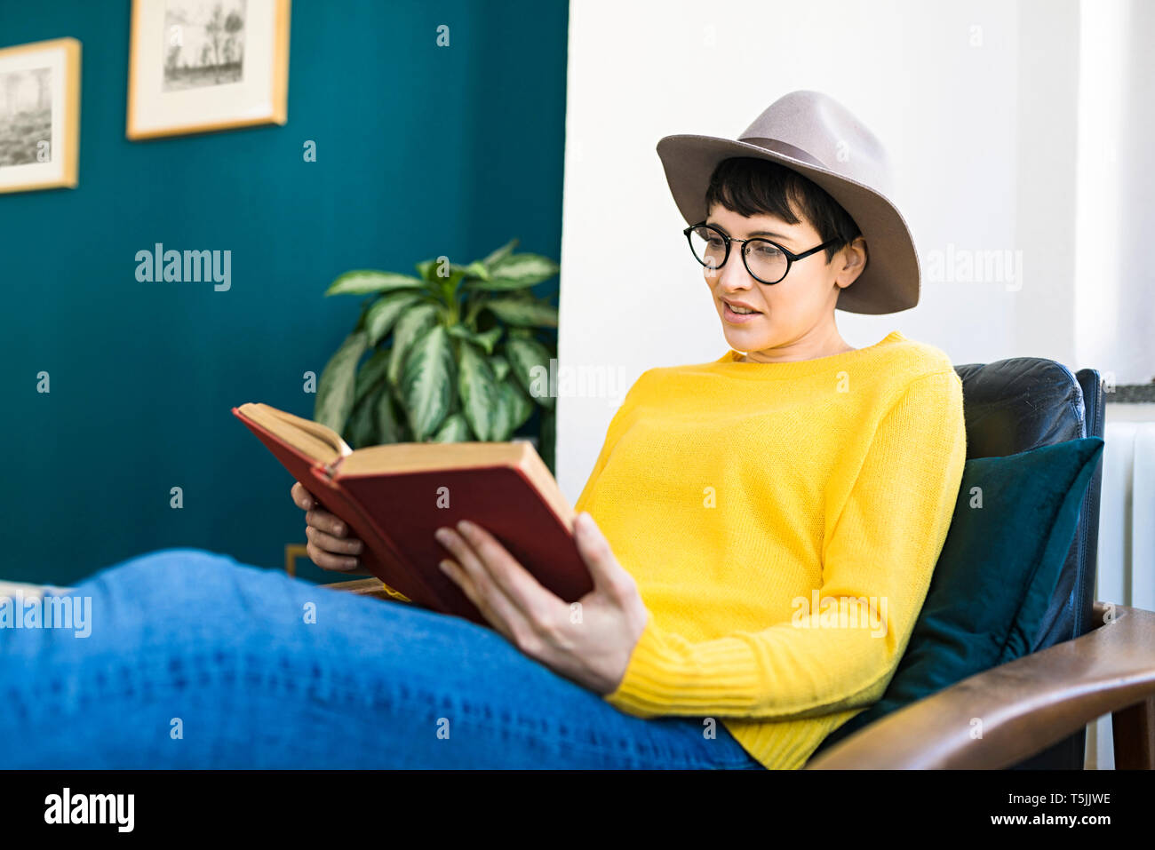Woman in chair reading a book hi-res stock photography and images - Alamy