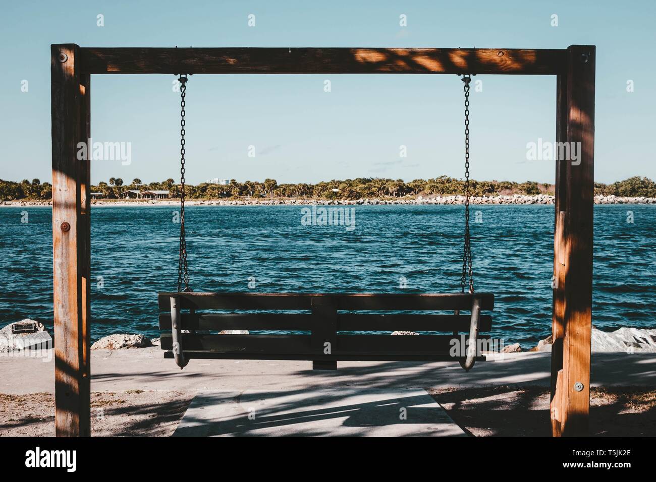 A two-person swing at the coast of a river Stock Photo - Alamy