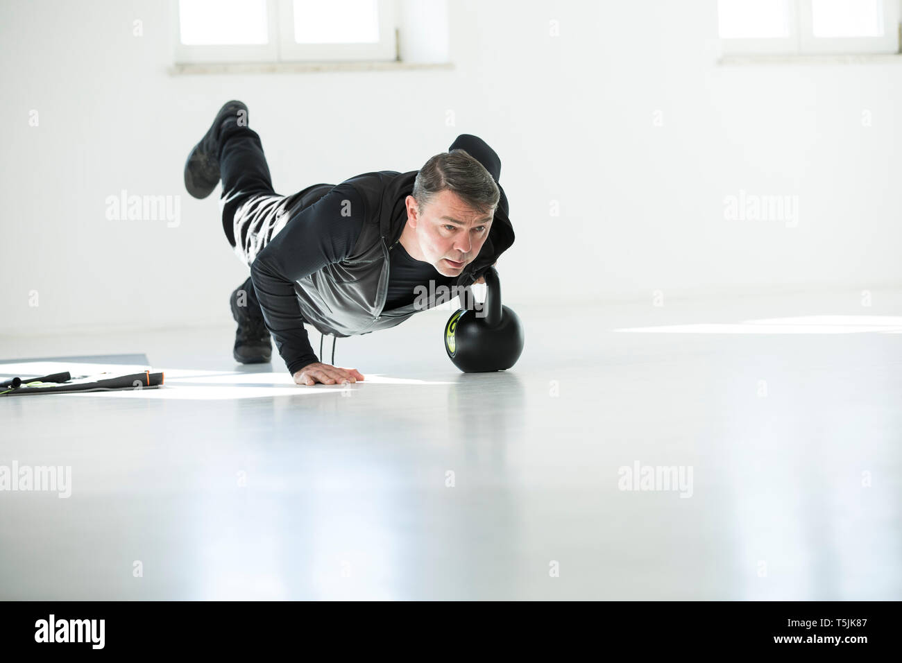Man doing his fitness regime, doing kettle bell push-ups Stock Photo ...