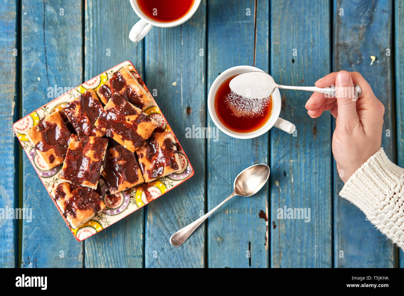 Woman's hand dispersing sugar into cup of tea Stock Photo - Alamy