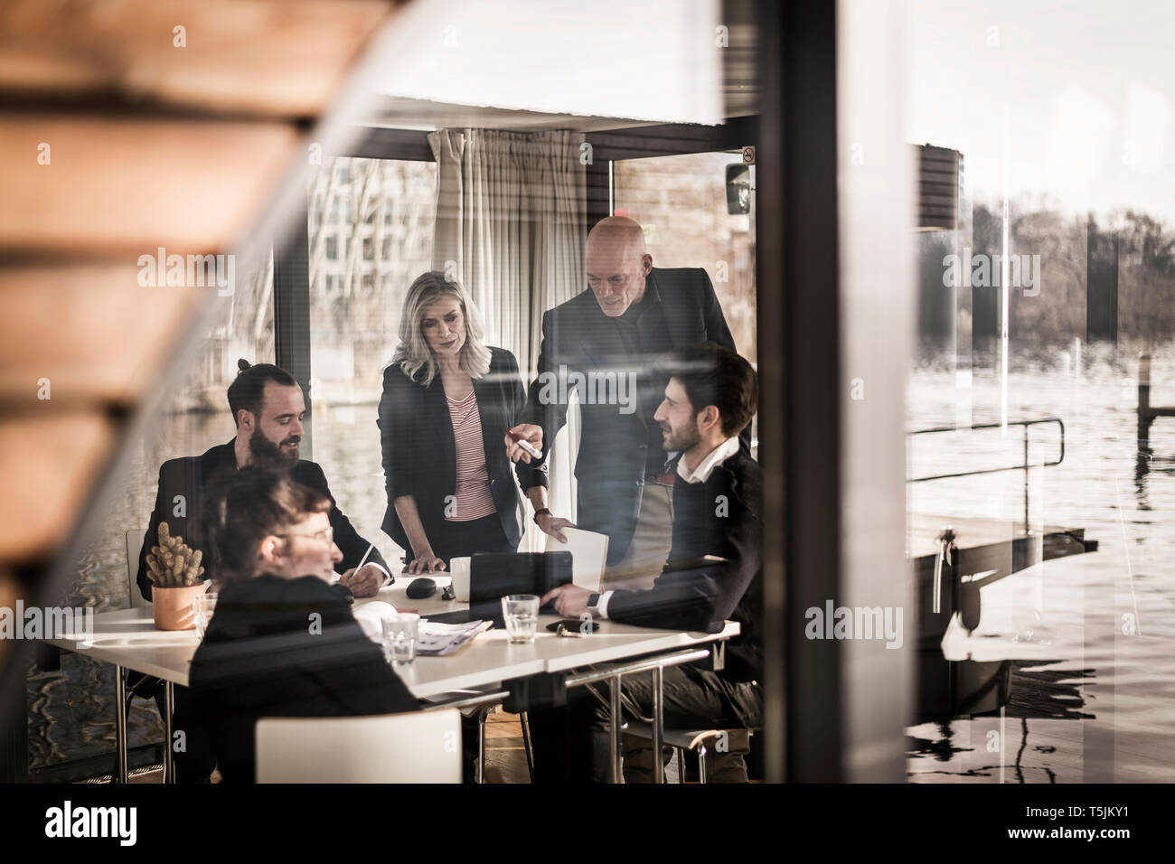 Creative business people having a team meeting in their houseboat ...