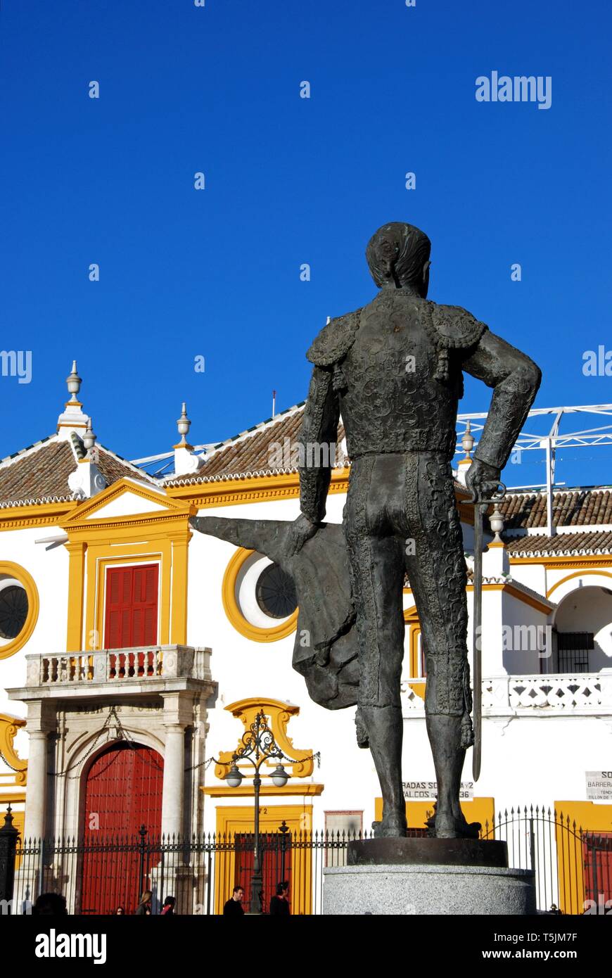 View of the bullring with a matador statue in the foreground, Seville ...