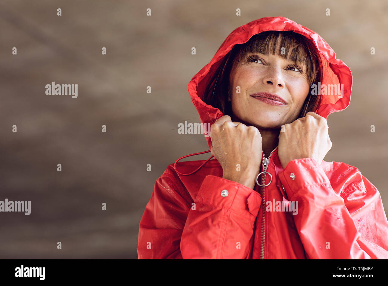 Woman wearing red rain coat, portrait Stock Photo - Alamy