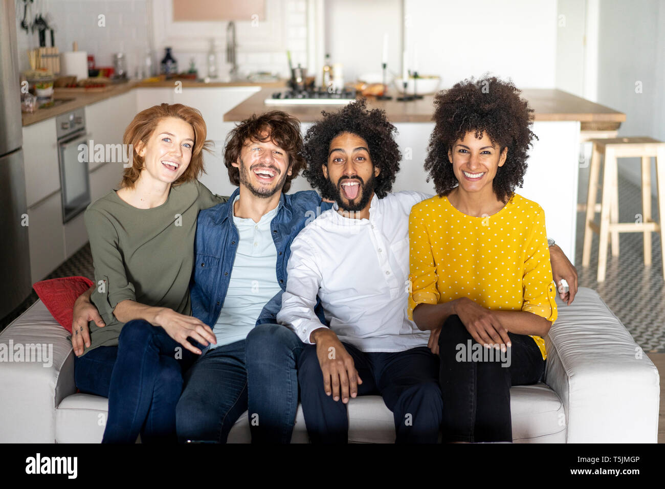 Friends meeting at home, sitting on couch, laughing Stock Photo - Alamy