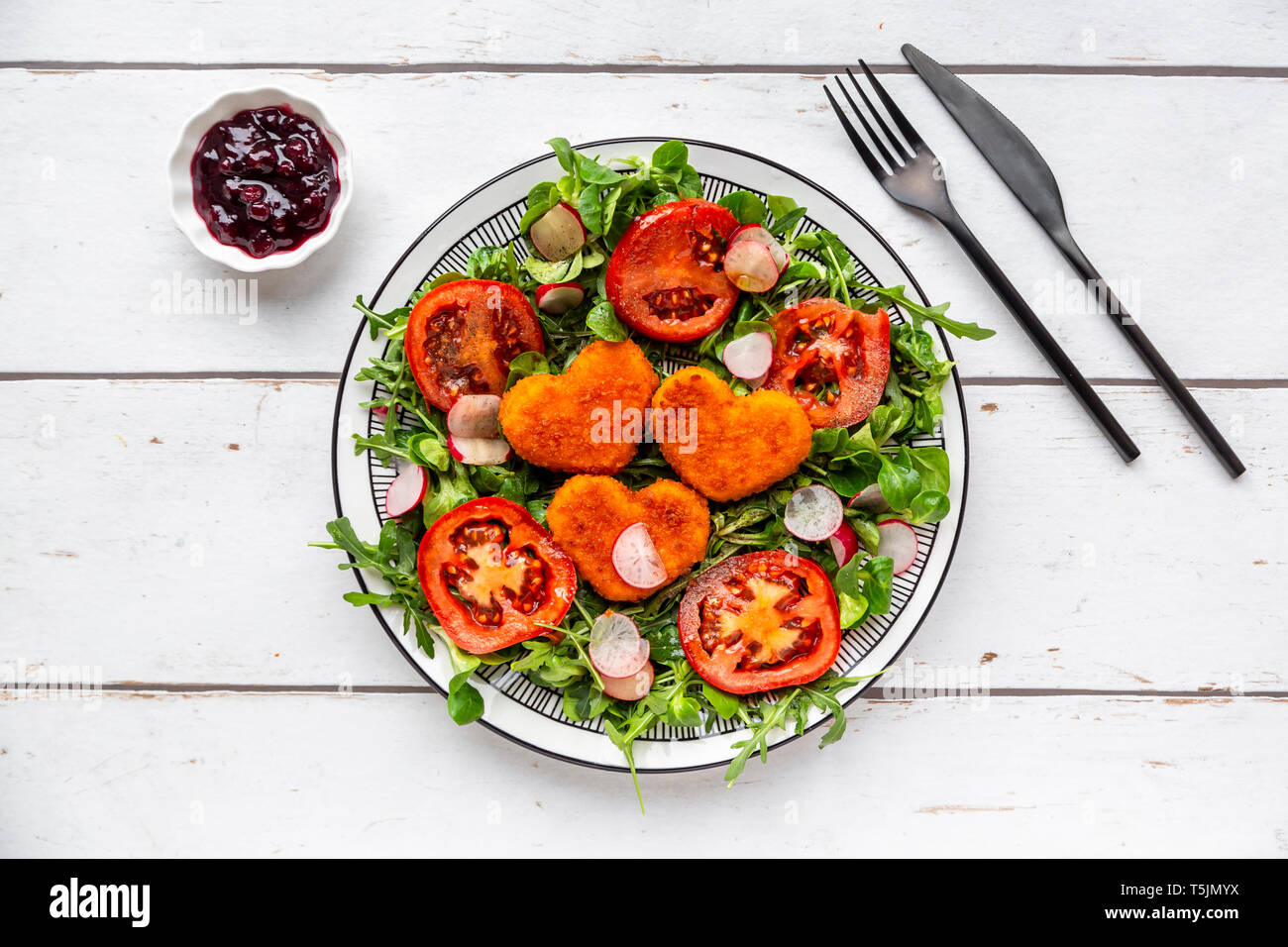 Baked camembert in heart shape with rocket, lamb's lettuce, tomato ...