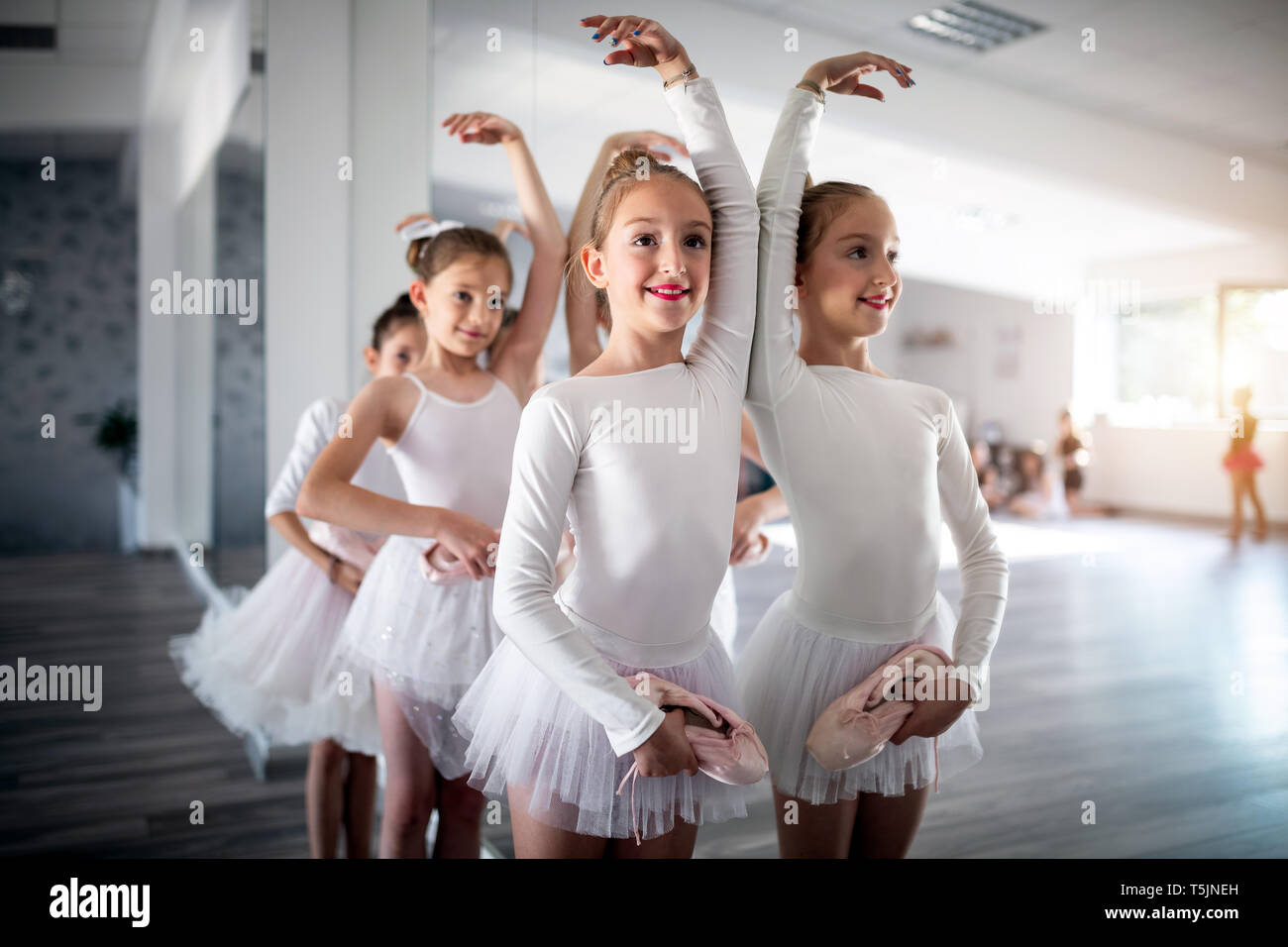 Group of fit happy children exercising ballet in studio together Stock ...
