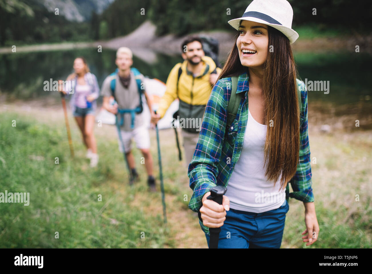 Group of young friends hiking in countryside. Multiracial happy people ...