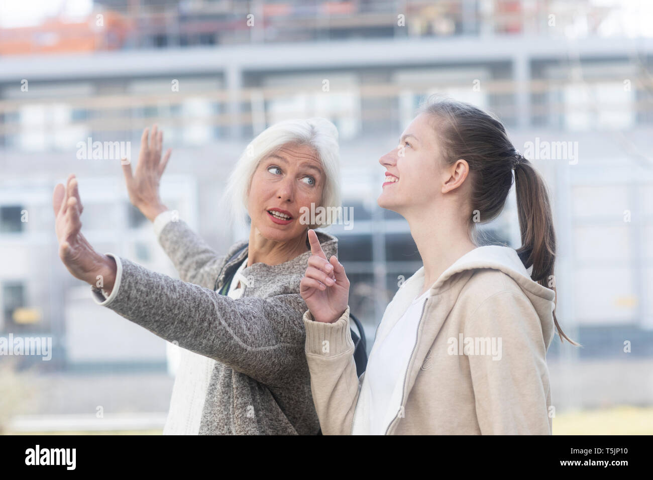 Portrait of mature woman explaining something to her adult daughter ...