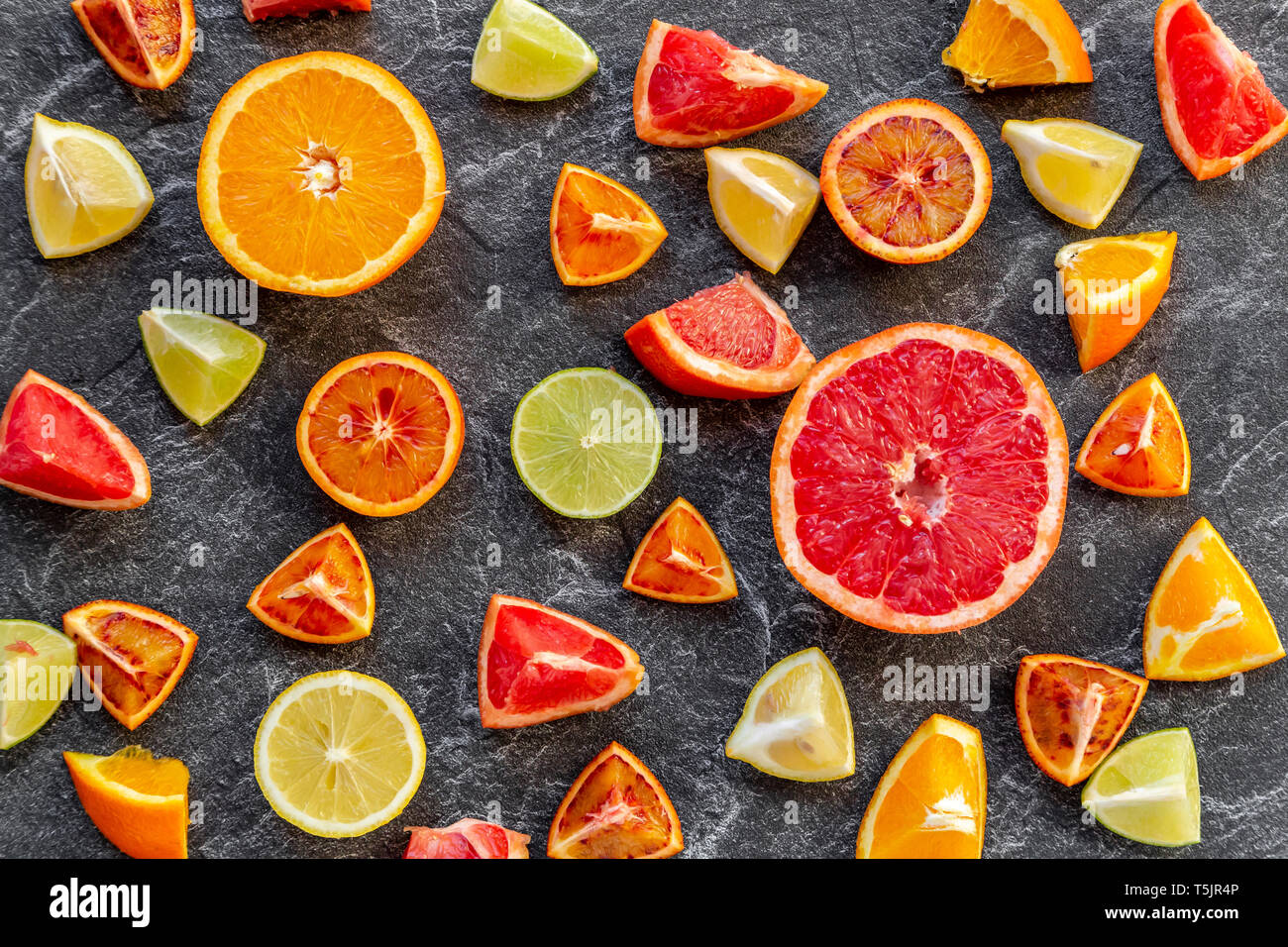 Sliced citrus fruits on slate Stock Photo - Alamy