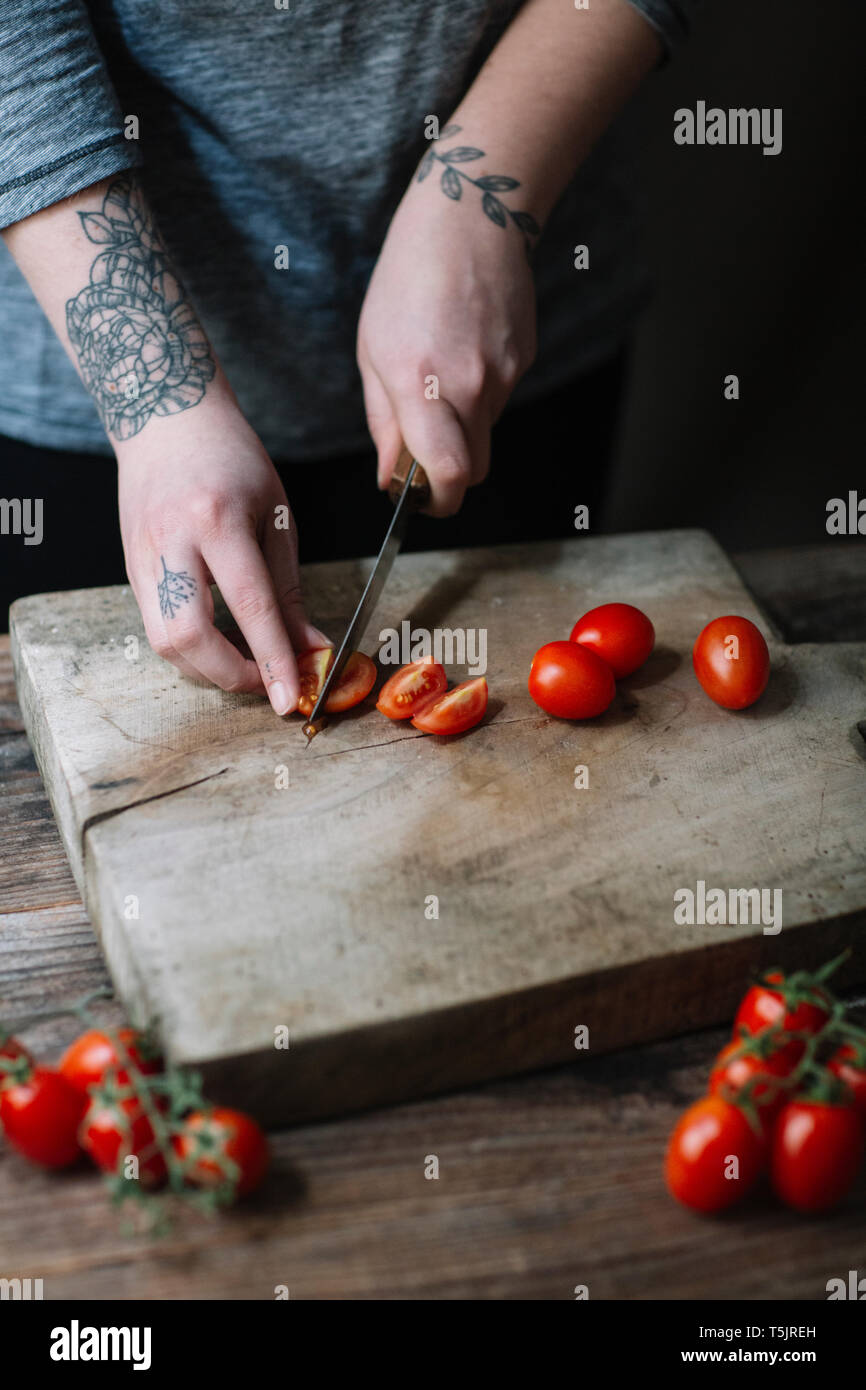 Young woman cutting tomatoes on chopping board Stock Photo - Alamy