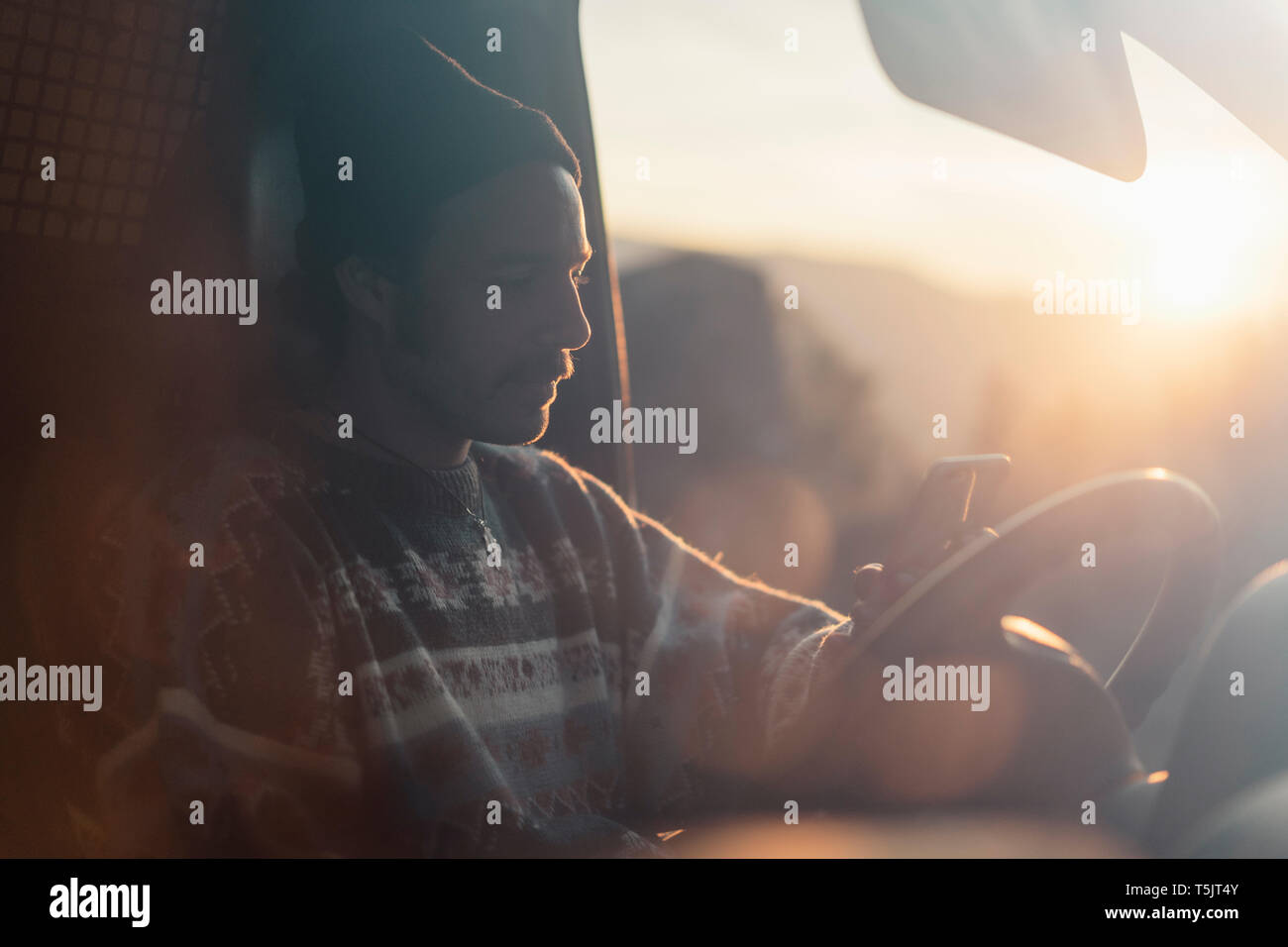 Young man on a road trip, using smartphone Stock Photo - Alamy