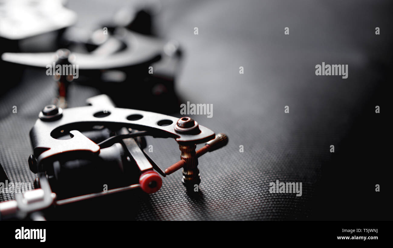 Tattoo machine and tattoo supplies on dark background - for banners ...