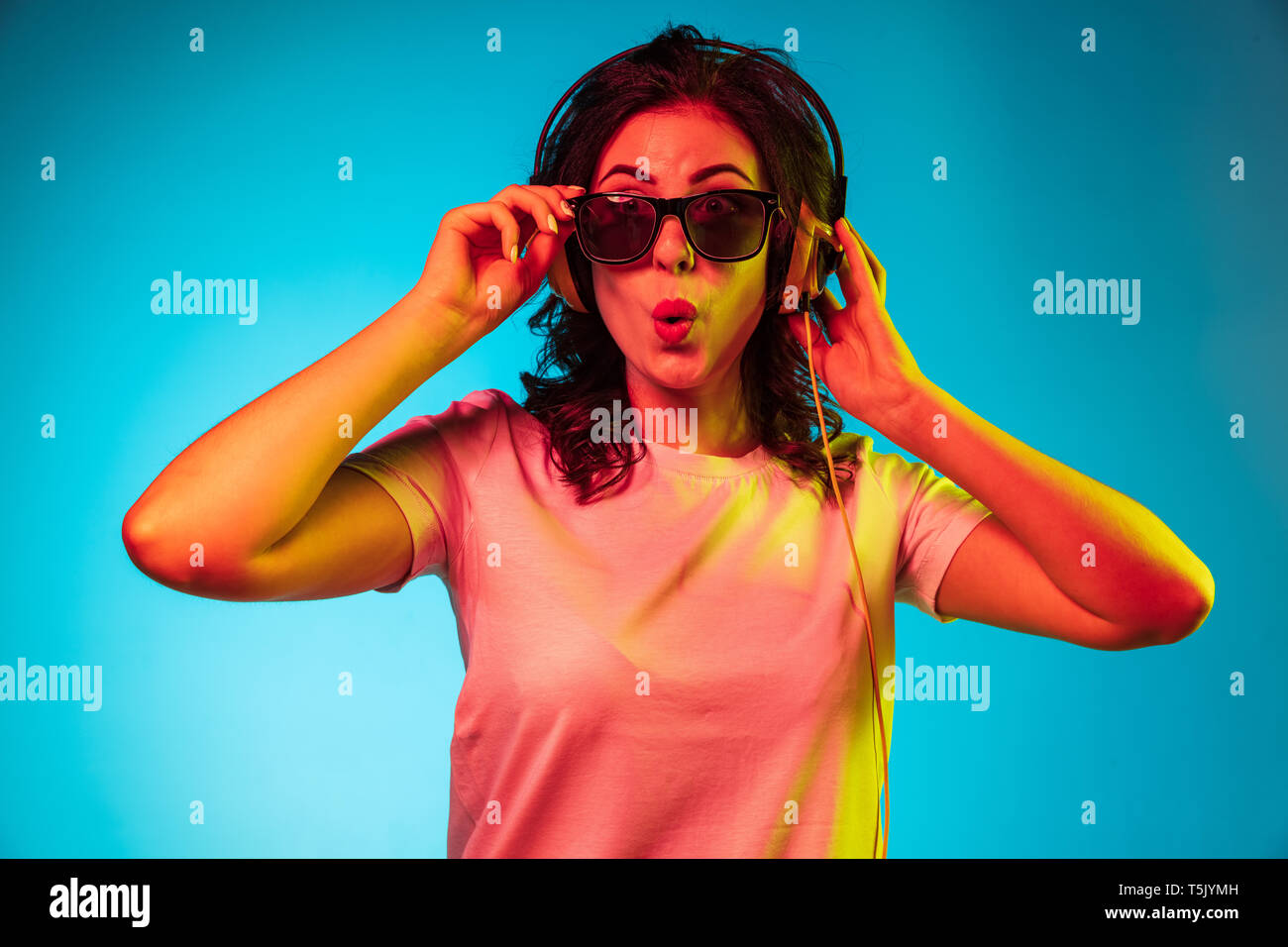 Young woman standing and listening to the music in sunglasses over ...
