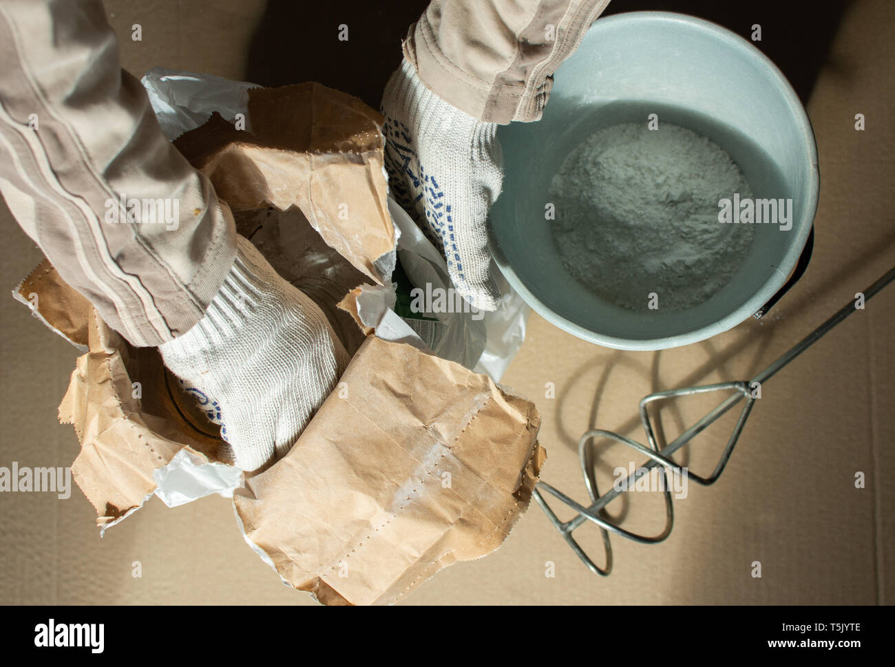 Man builder prepares a mixture for putty, bag with gypsum putty and ...