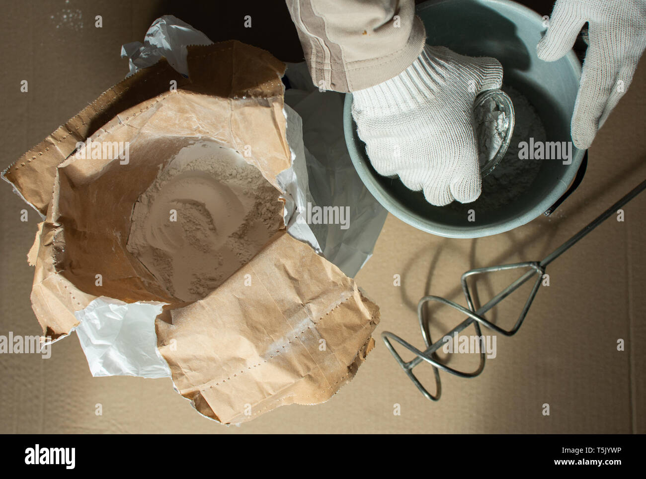 Man builder prepares a mixture for putty, bag with gypsum putty and ...