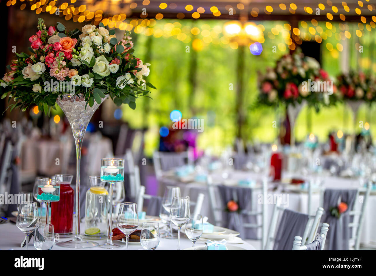 Wedding table decoration. Beautiful bouquet of flowers in vase on the ...