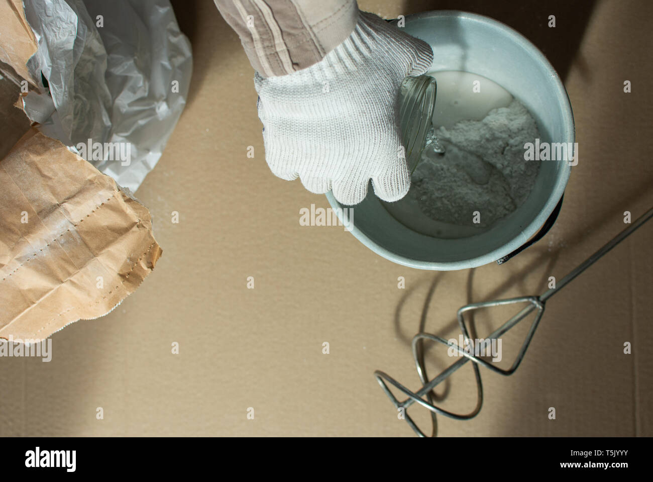 Man builder prepares a mixture for putty, bag with gypsum putty and ...