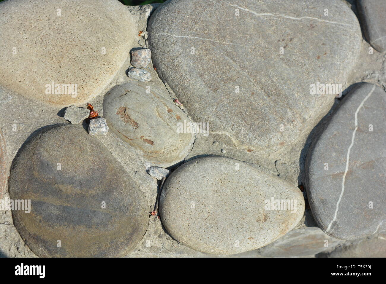 Large smooth sea stones with cement, original architectural background ...