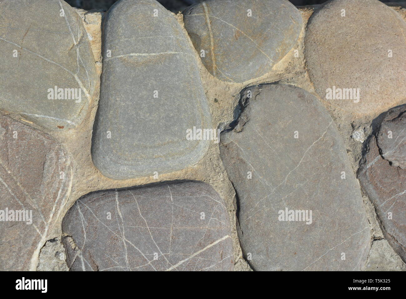 Large smooth sea stones with cement, original architectural background ...