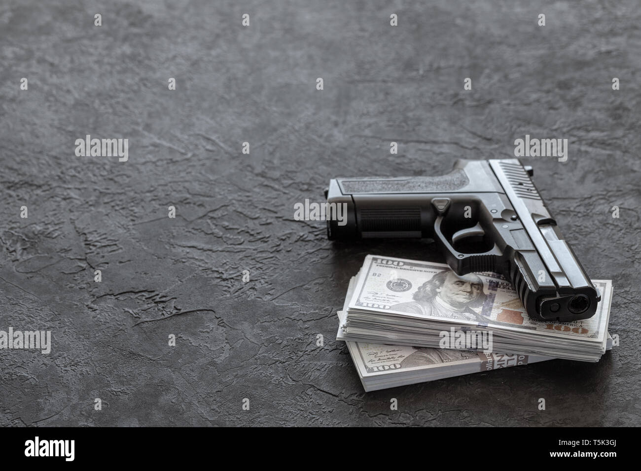 Pistol and money. Guns and dollars on black background. Copy space for ...