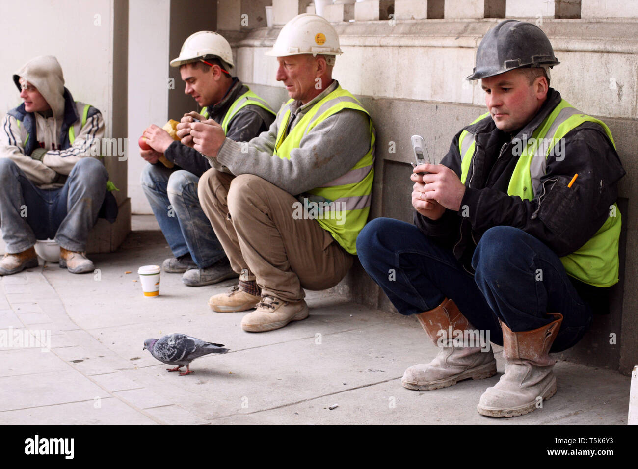 Construction workers on their lunch break sitting down together and ...