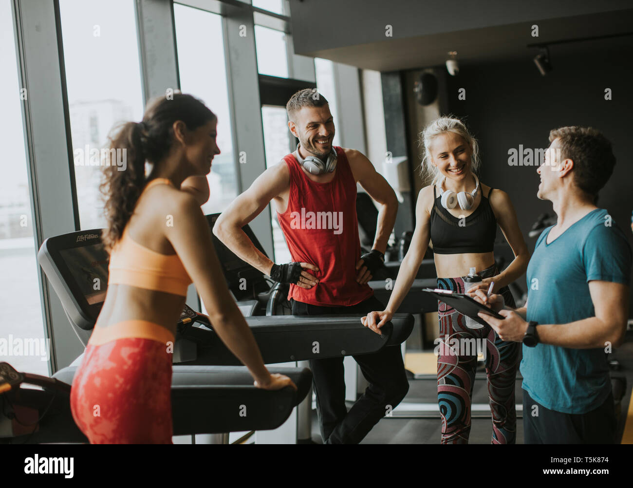 Group of young people in sportswear talking in a gym after a workout ...