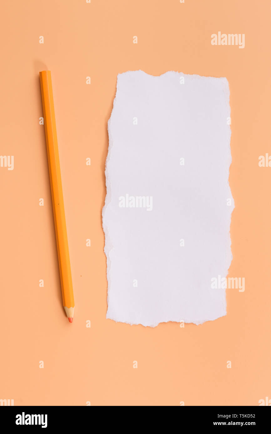 A piece of white torned paper over orange background with pencil Stock ...