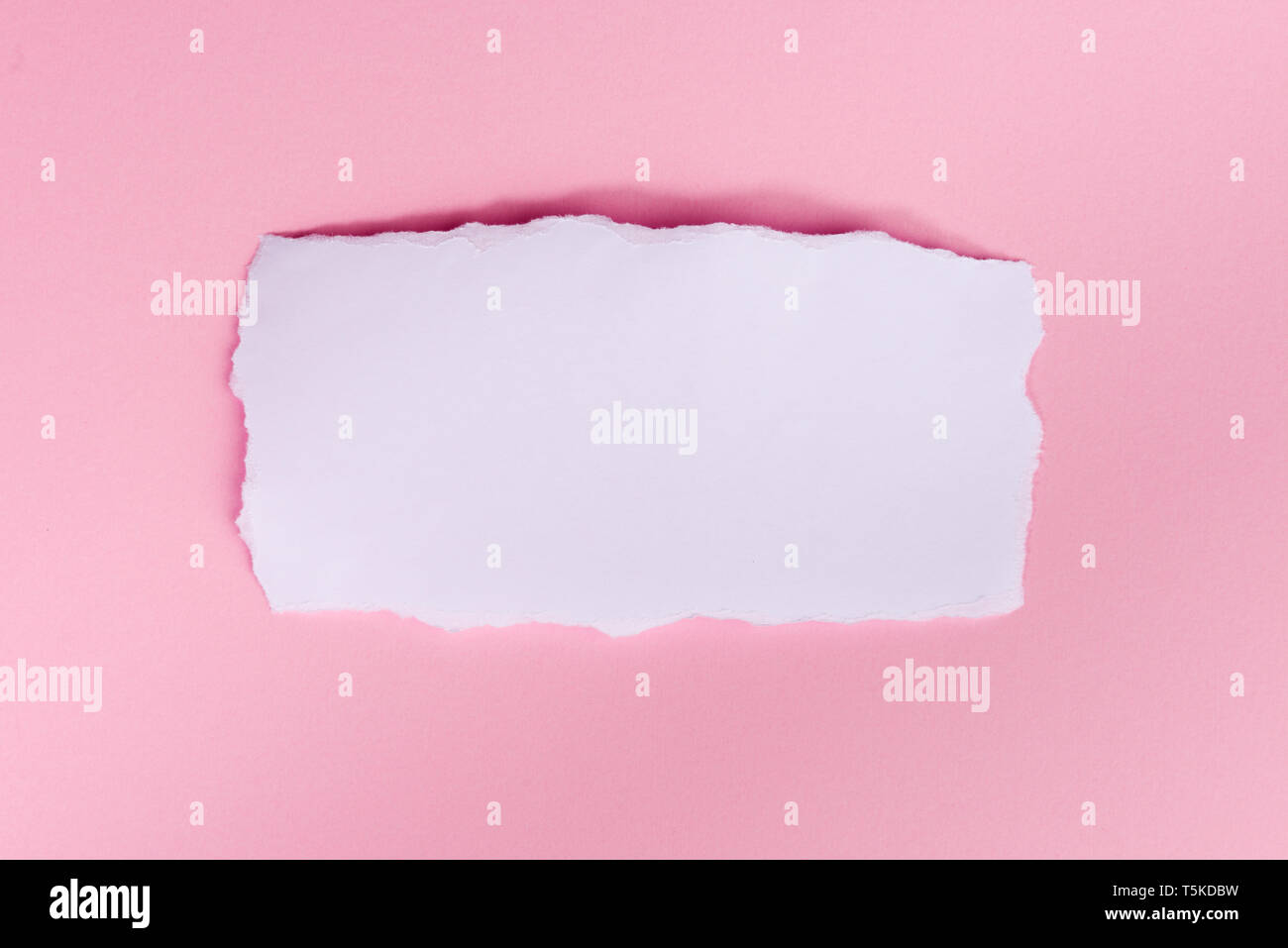 A piece of white torned paper over pink background Stock Photo - Alamy