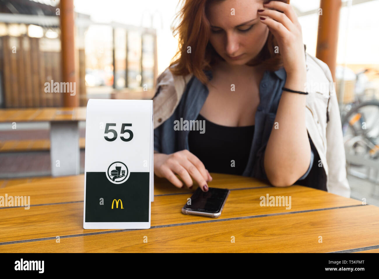 RIGA, LATVIA - APRIL 22, 2019: Waiting for order and thinking about her ...