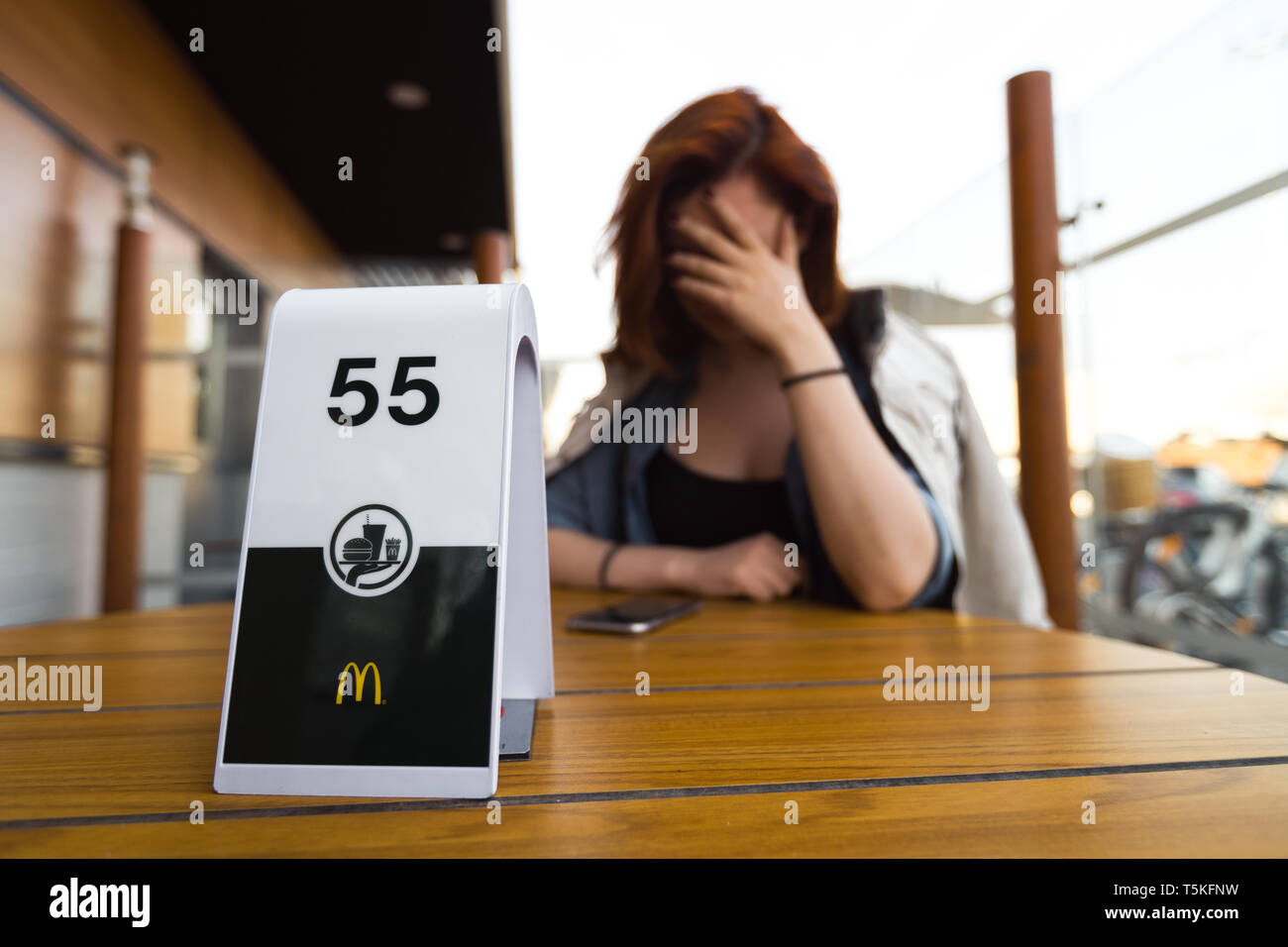 RIGA, LATVIA - APRIL 22, 2019: Waiting for order and thinking about her ...