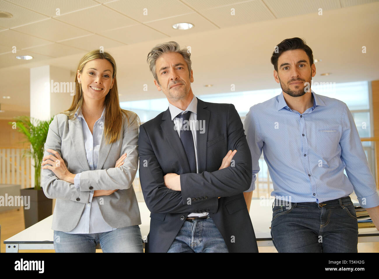 Attractive mixed business team smiling at camera Stock Photo - Alamy