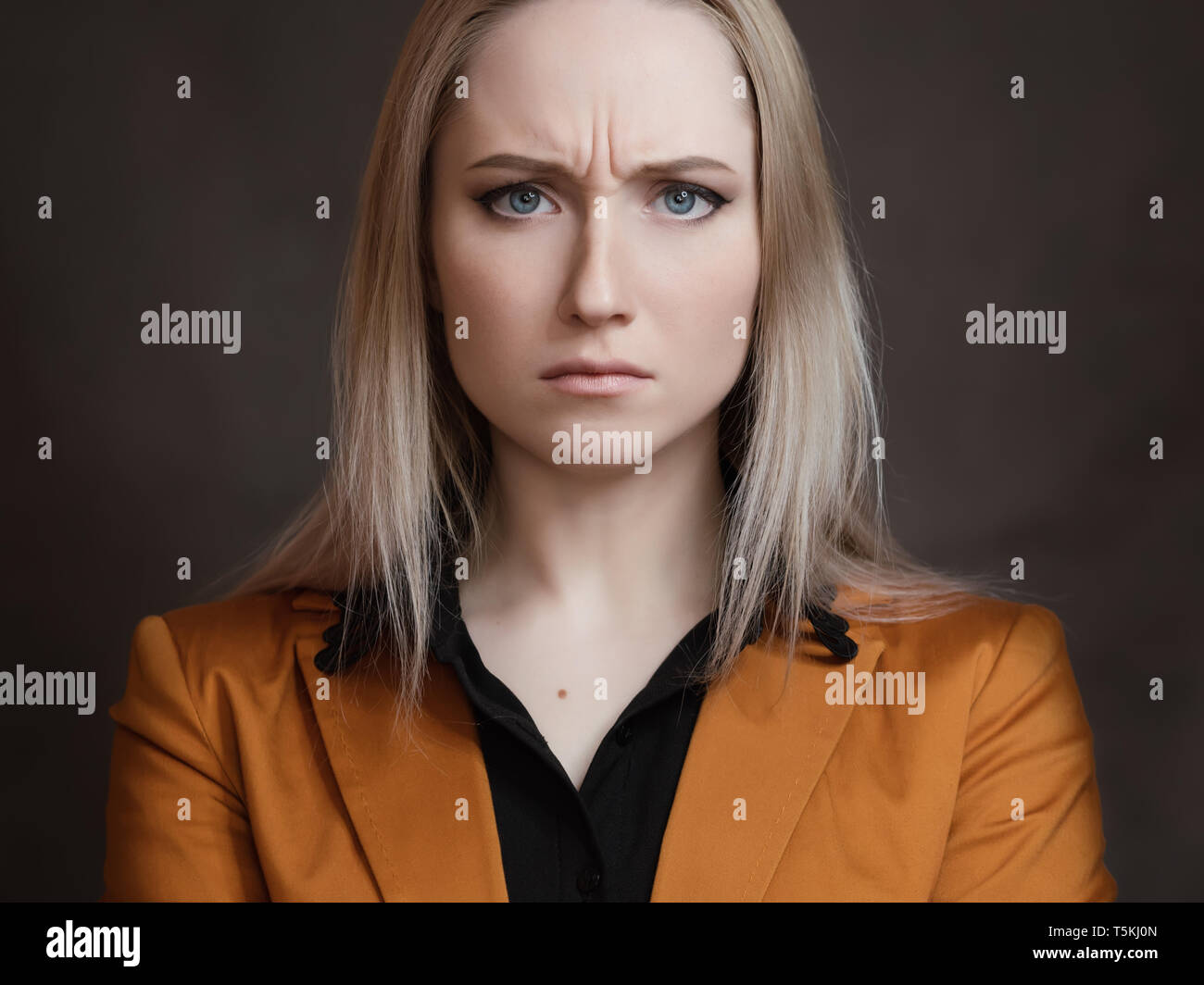 Woman with a strict look on a dark background Stock Photo - Alamy