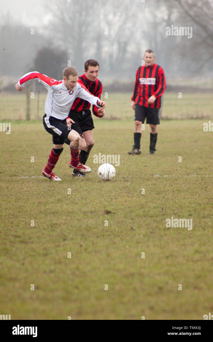 Men competing in a football match Stock Photo - Alamy