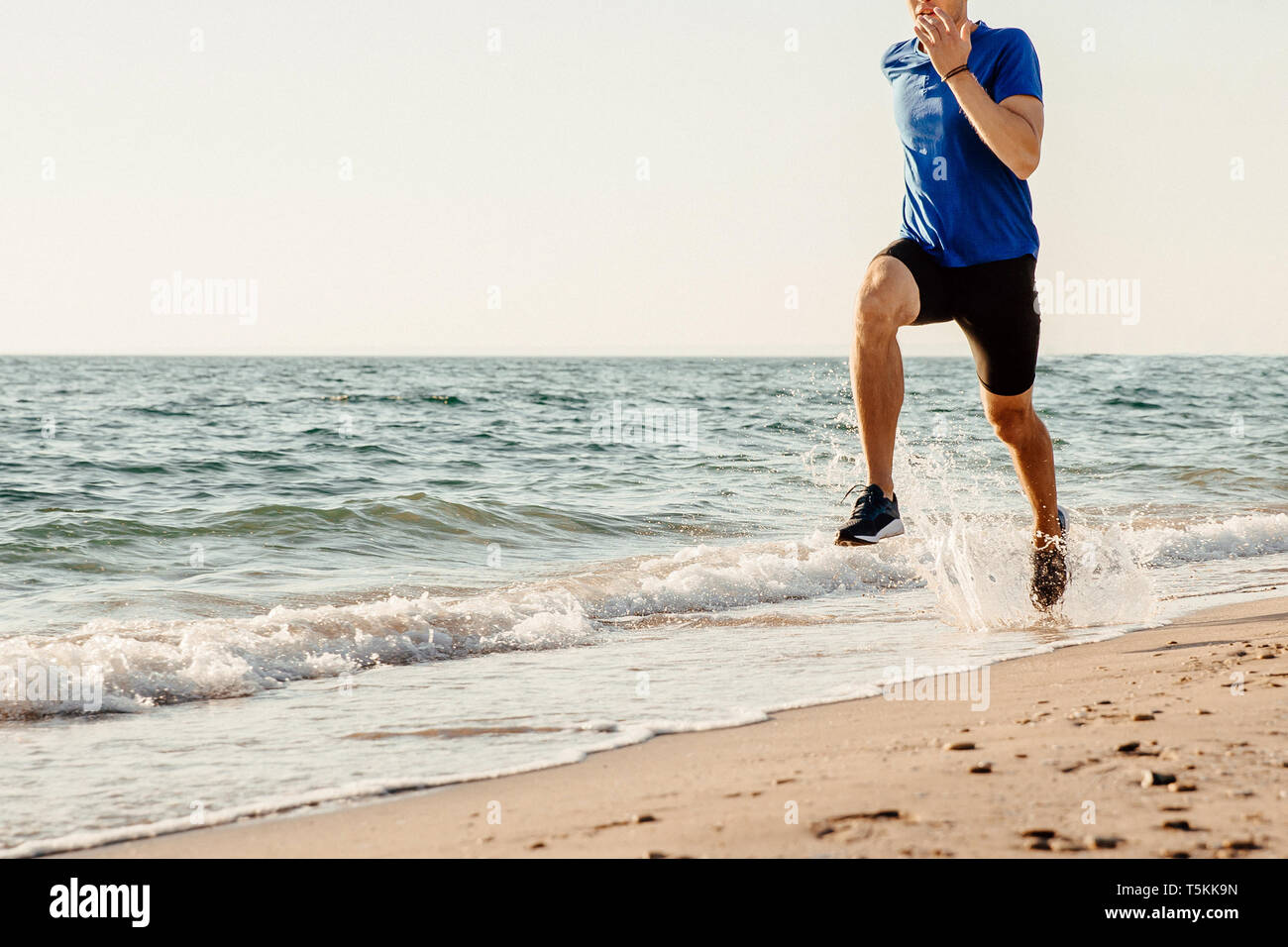 male runner running on sea of sandy beach water spray Stock Photo - Alamy