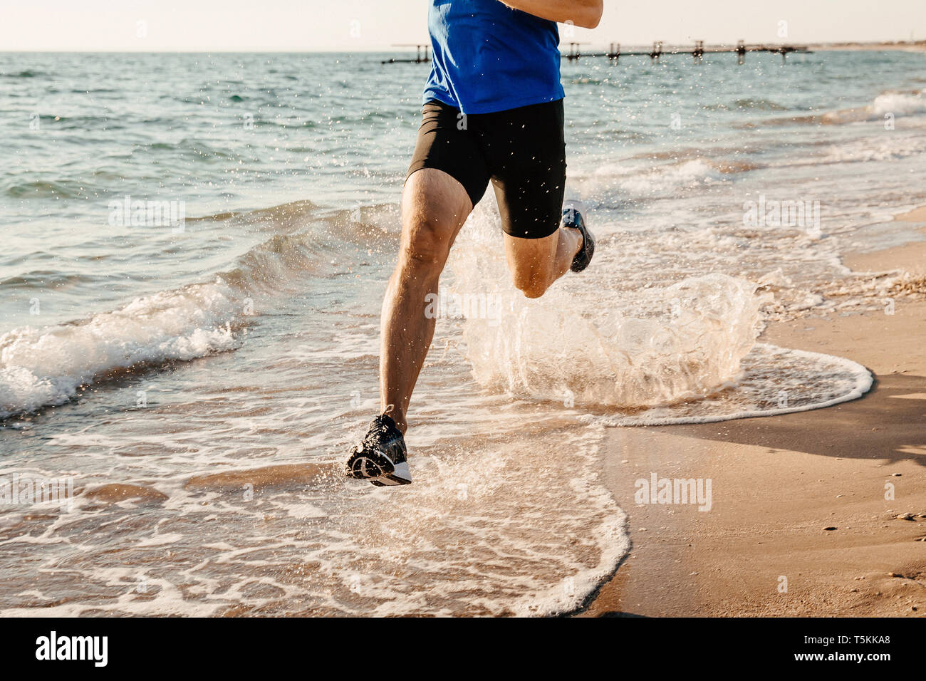 Man running into waves hi-res stock photography and images - Alamy