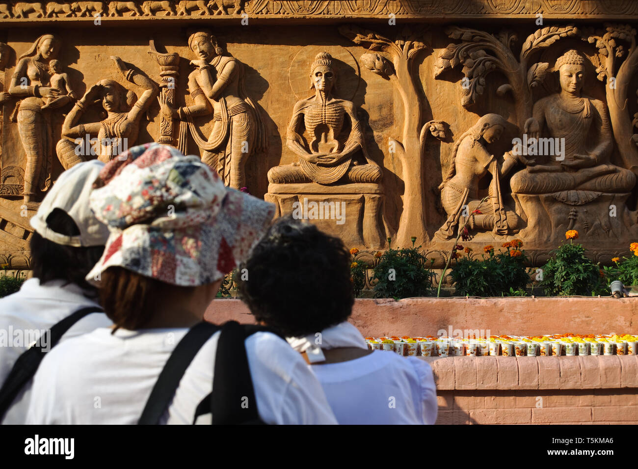 Buddhist pilgrims are watching sculptures depicting Buddha's life at ...