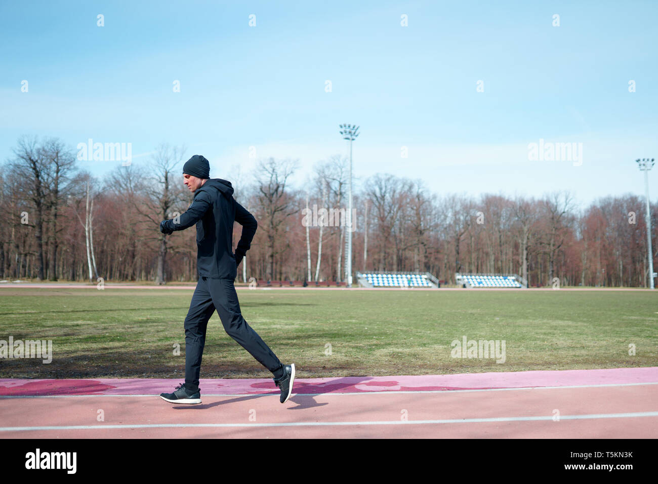 Image of athlete male running through stadium during spring jog in ...