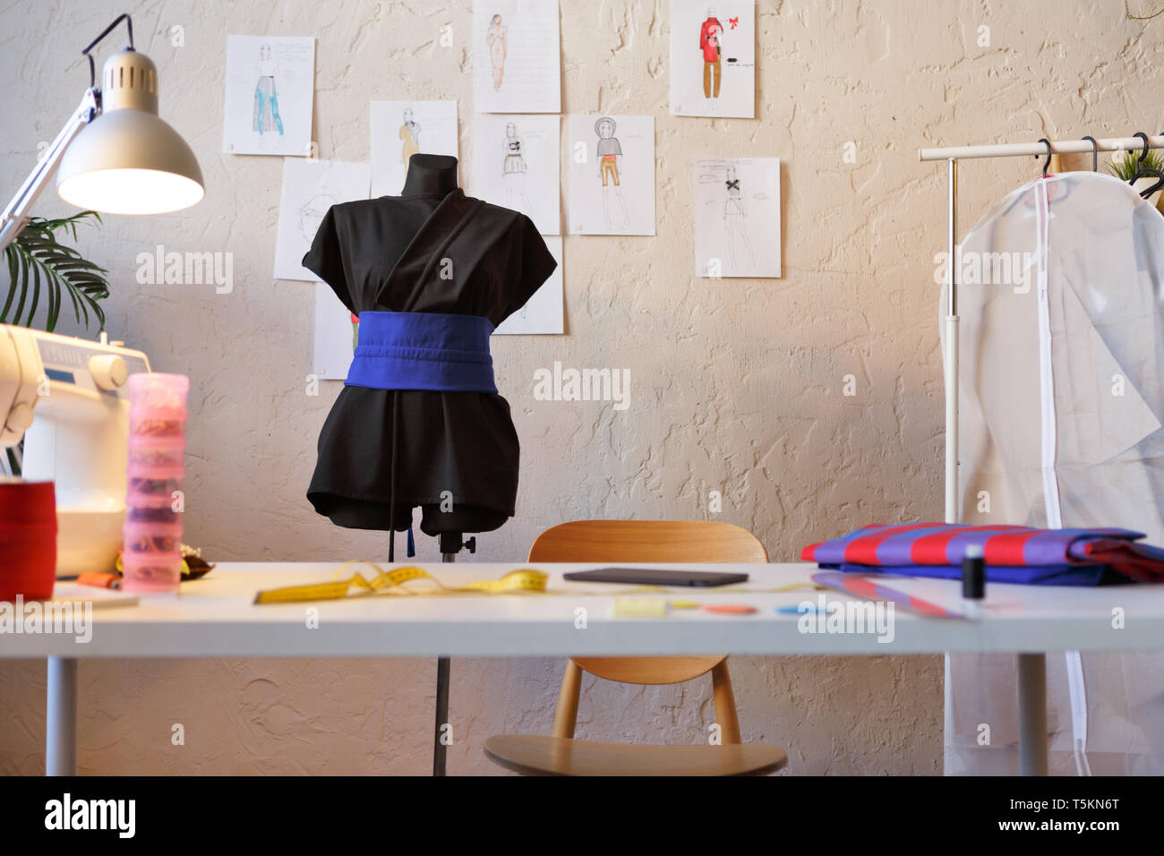 Photo of seamstress room with mannequin, table, sewing machine, dresses ...