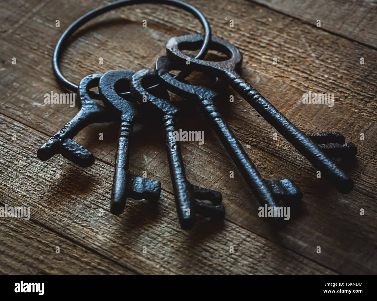 Hand forged wrought iron keys on a vintage antique wooden table ...