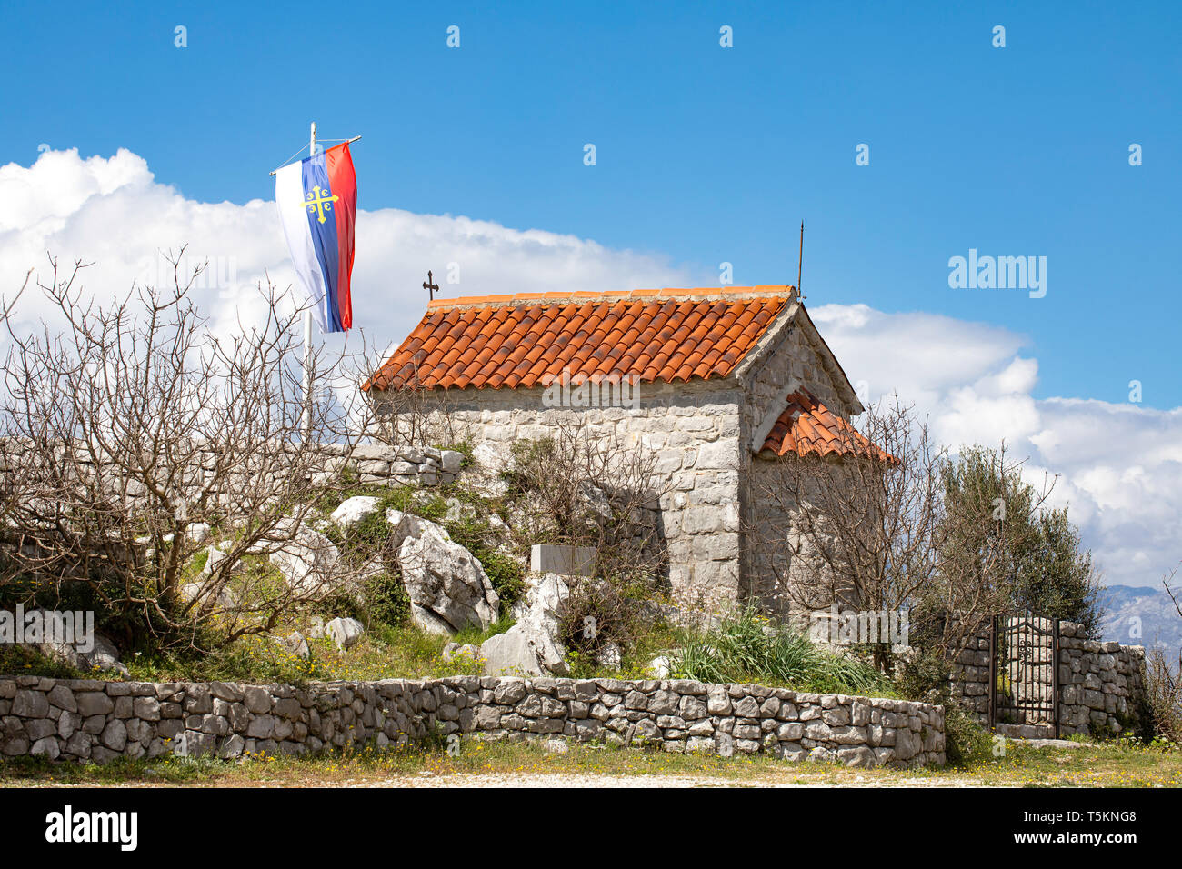 Serbian Orthodox Church flag by a little shrine. Sacral architecture ...