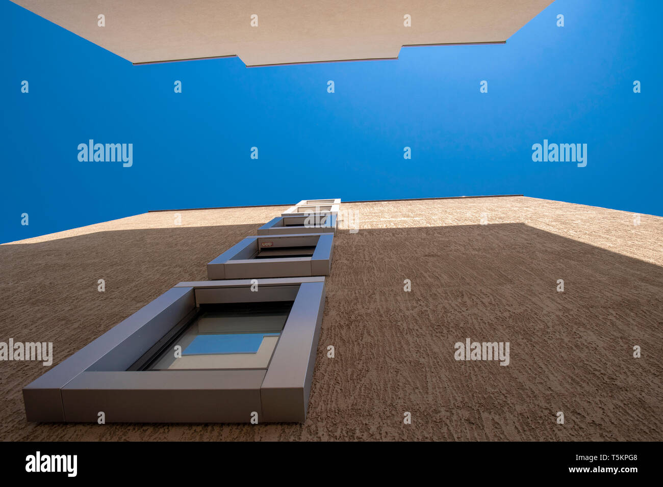 interesting architecture with windows in a line to the top and blue sky ...