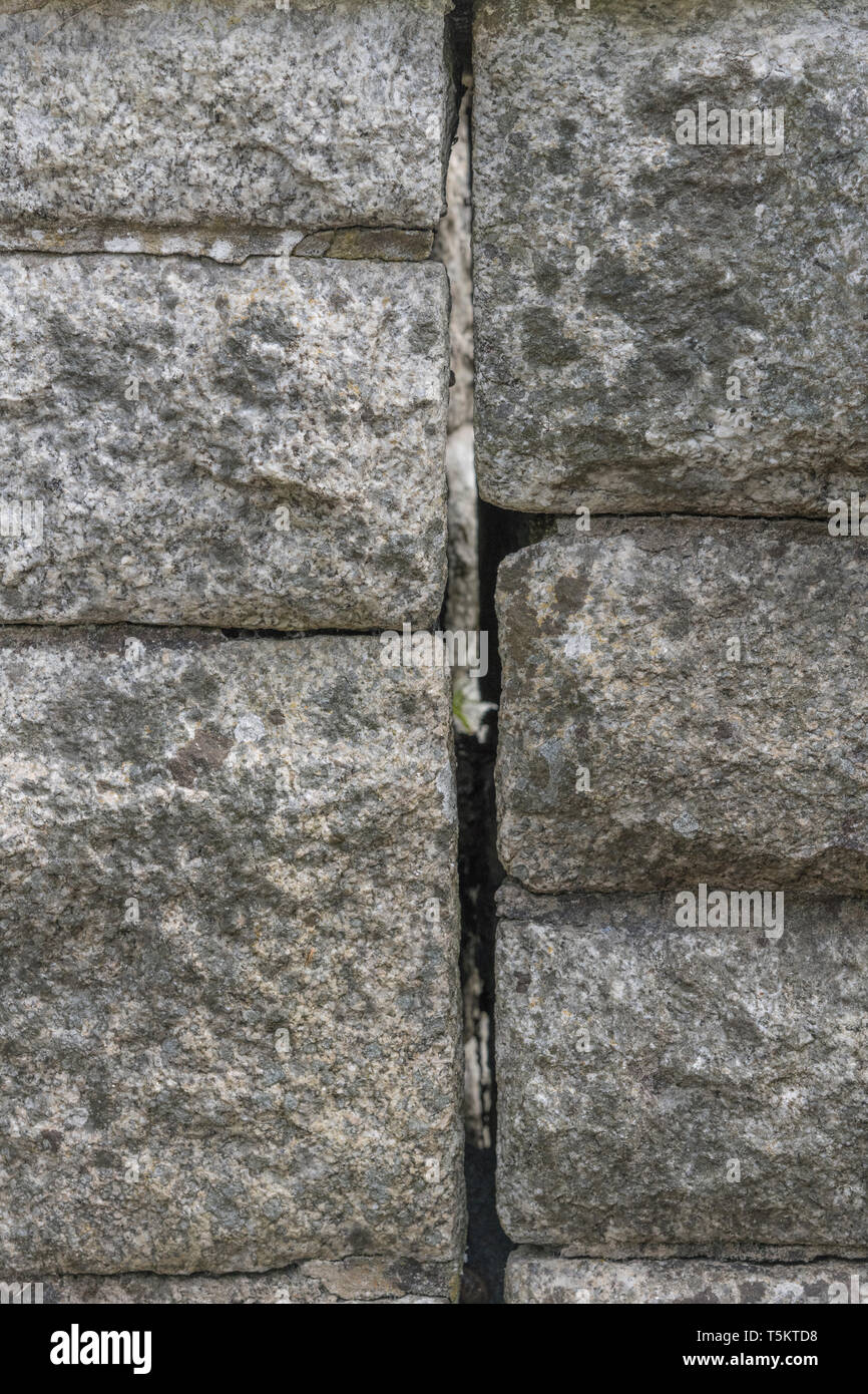 Stone wall with a fissure in the structure which shows light from ...