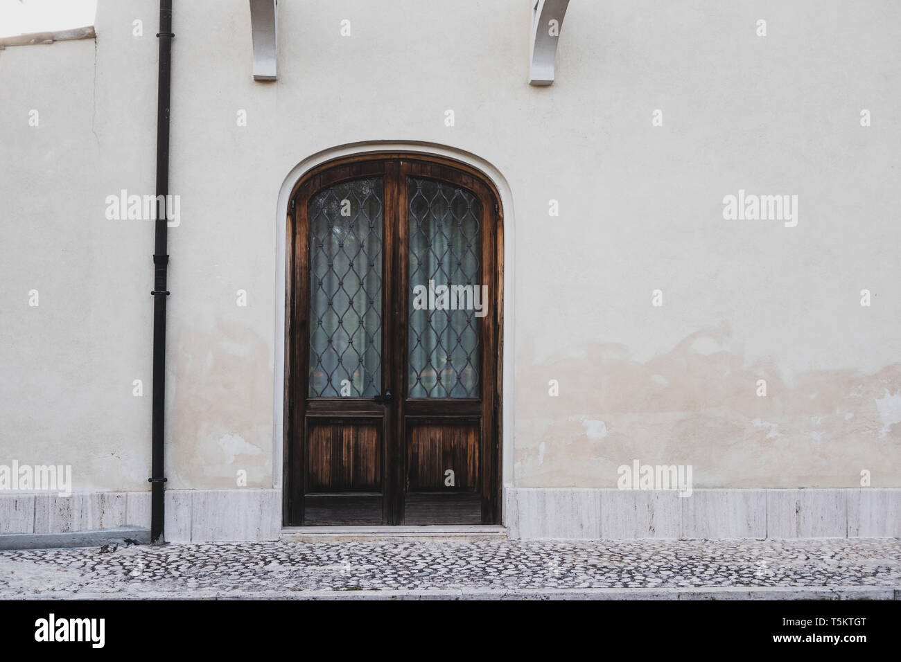 Building exterior front view of wall and closed door with pebble ...