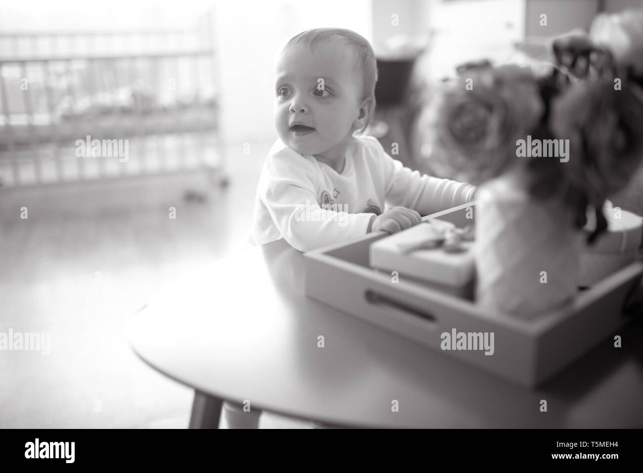 A toddler plays in the nursery. Black and white image Stock Photo - Alamy