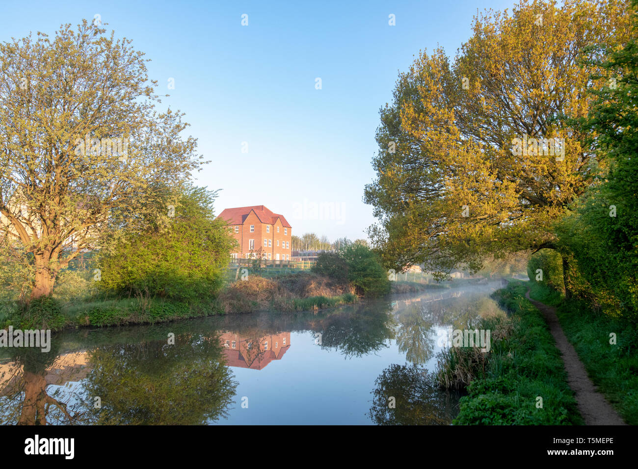 Spring trees reflecting in the oxford canal opposite the longford park ...
