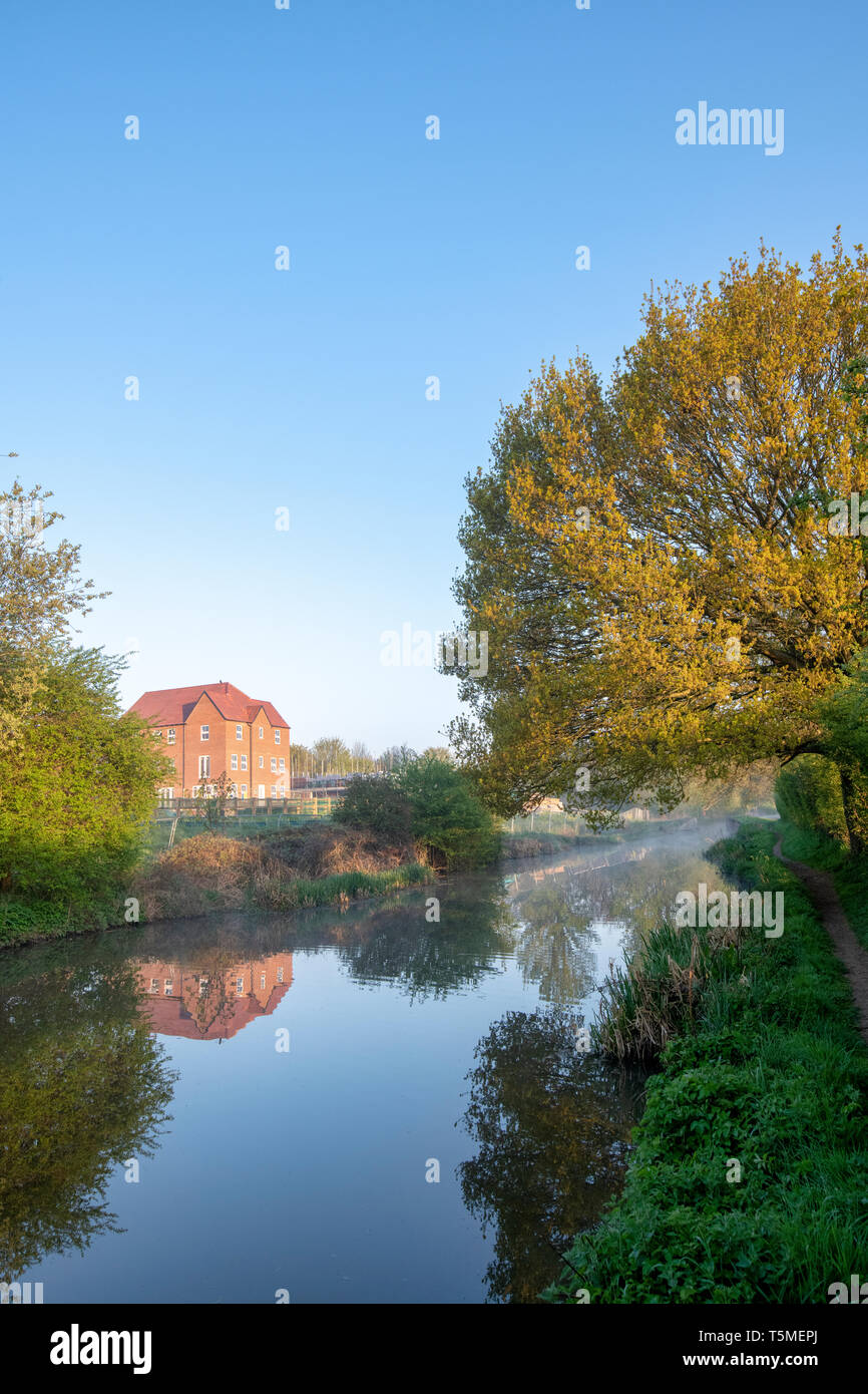 Spring trees reflecting in the oxford canal opposite the longford park ...