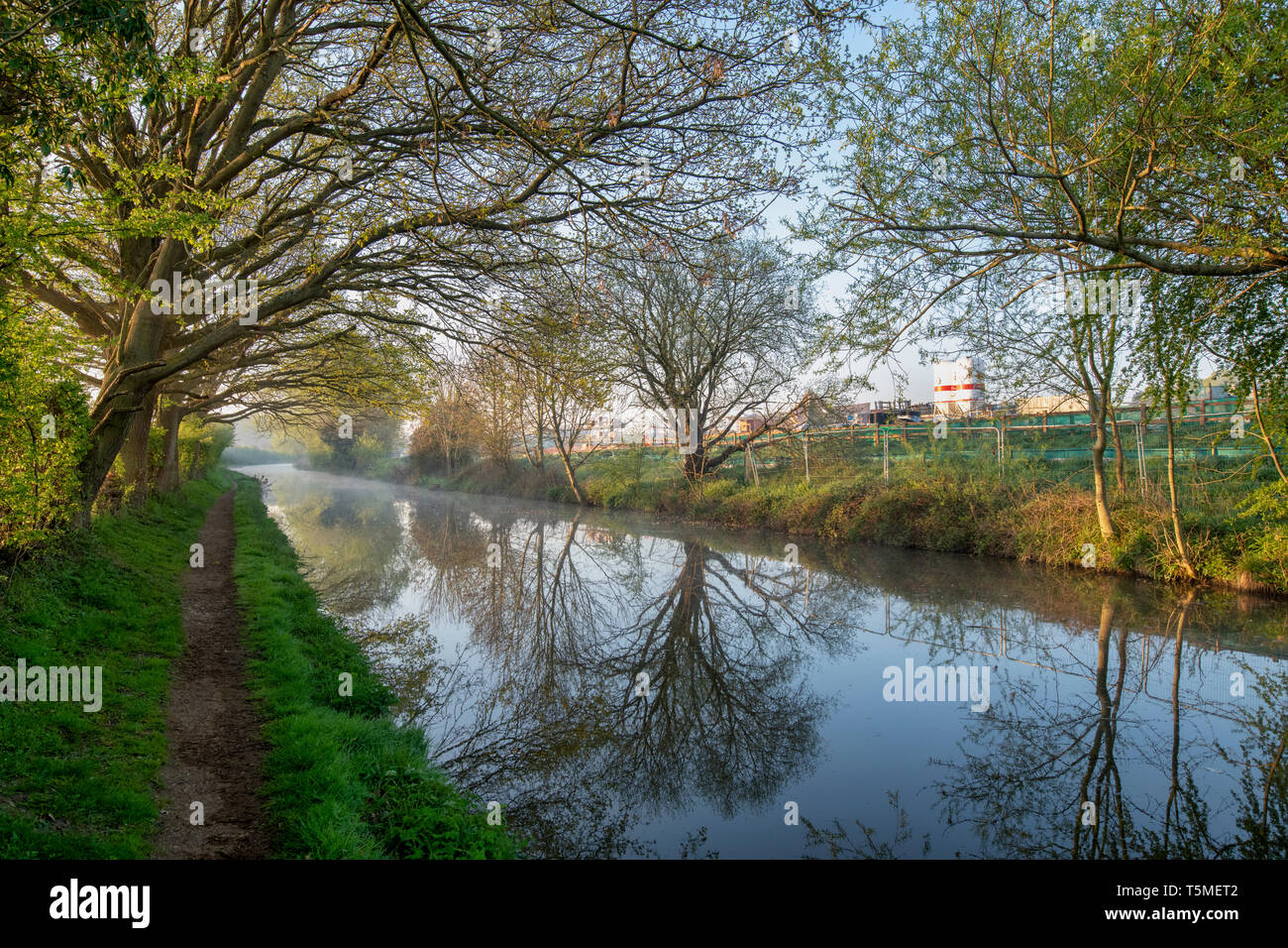 Spring trees reflecting in the oxford canal opposite the longford park ...